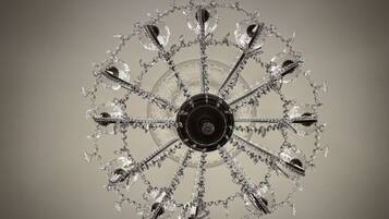 Um candelabro com vários braços e detalhes em cristal.