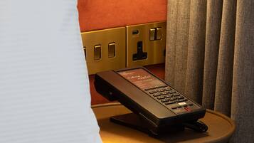 Um comando remoto sobre uma mesa de cabeceira num quarto de hotel.
