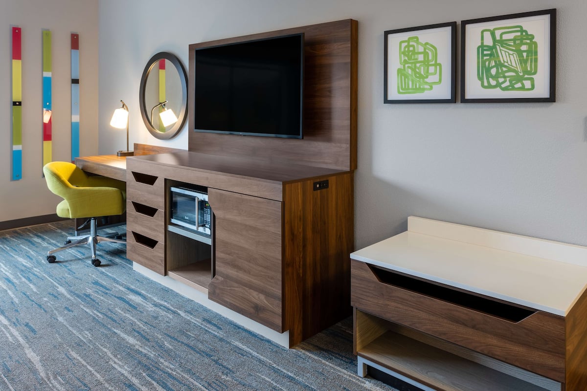 Um espaço de escritório moderno com uma mesa, cadeira e TV integrada.