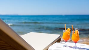 Dois cocktails sobre uma mesa branca, com vista para o oceano.
