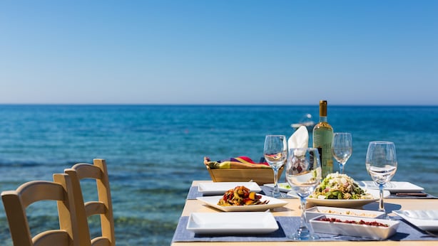 Mesa posta para refeição com vista para o mar.