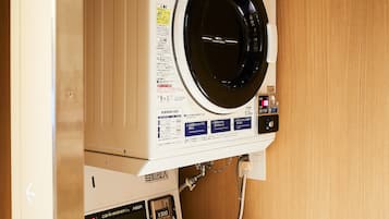 Vista frontal de uma máquina de lavar com painel de controle, entrada de água e saída de água.