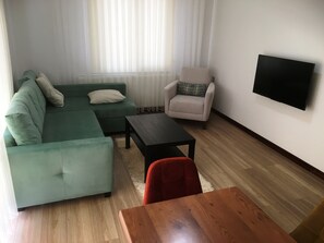 Apartamento Comfort em Condomínio Fechado, varanda | Sala de estar | Televisor LCD de 70 cm com canais via satélite 