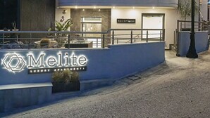 Um edifício de vários andares com área de recepção, varandas e uma placa com a inscrição 'Melite Luxury Apartments'.