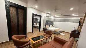 Uma sala de estar moderna com um sofá, poltronas e uma mesa de centro de vidro.