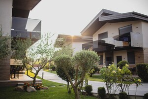 Um bairro residencial moderno com casas, um gramado bem cuidado e céu limpo.