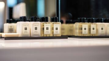 Vários frascos de perfume Jo Malone London sobre uma superfície branca.