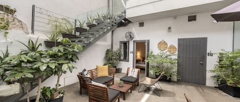 Uma área externa moderna para relaxar, com escada, assentos e plantas em vasos.