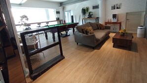 Uma sala de estar espaçosa com mesa de bilhar, sofá e mesa de centro.
