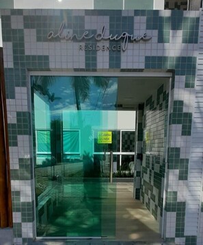 Um edifício residencial com fachada revestida de azulejos e uma janela grande.