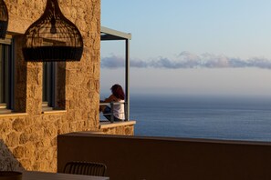 Um edifício de pedra com varanda com vista para o mar.