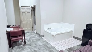 Casa de banho com banheira, sanita e zona de duche.