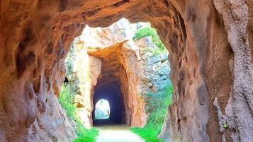 Um arco de pedra natural que dá acesso a uma túnel.