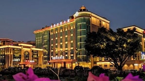 Um hotel de vários andares com fachada de vidro marcante e design de canto curvo.