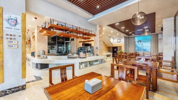 Restaurante moderno com mobiliário de madeira e um balcão central.