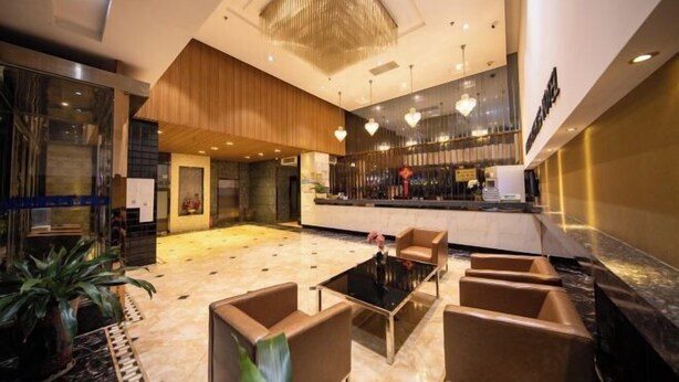 Um hall amplo com balcão de recepção, área de estar e bar.