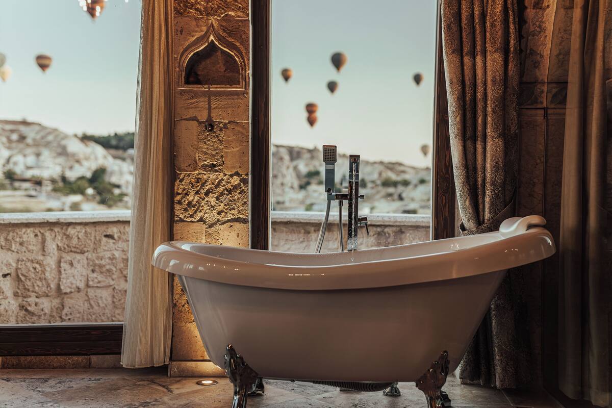 Uma banheira em um quarto com vista para balões de ar quente.
