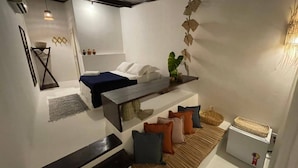 Quarto compacto com cama, um espaço de estar pequeno e uma cozinha compacta.