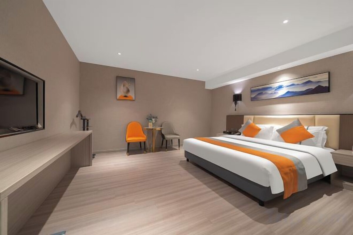 Quarto de hotel moderno com uma cama grande, uma escrivaninha e uma cadeira.