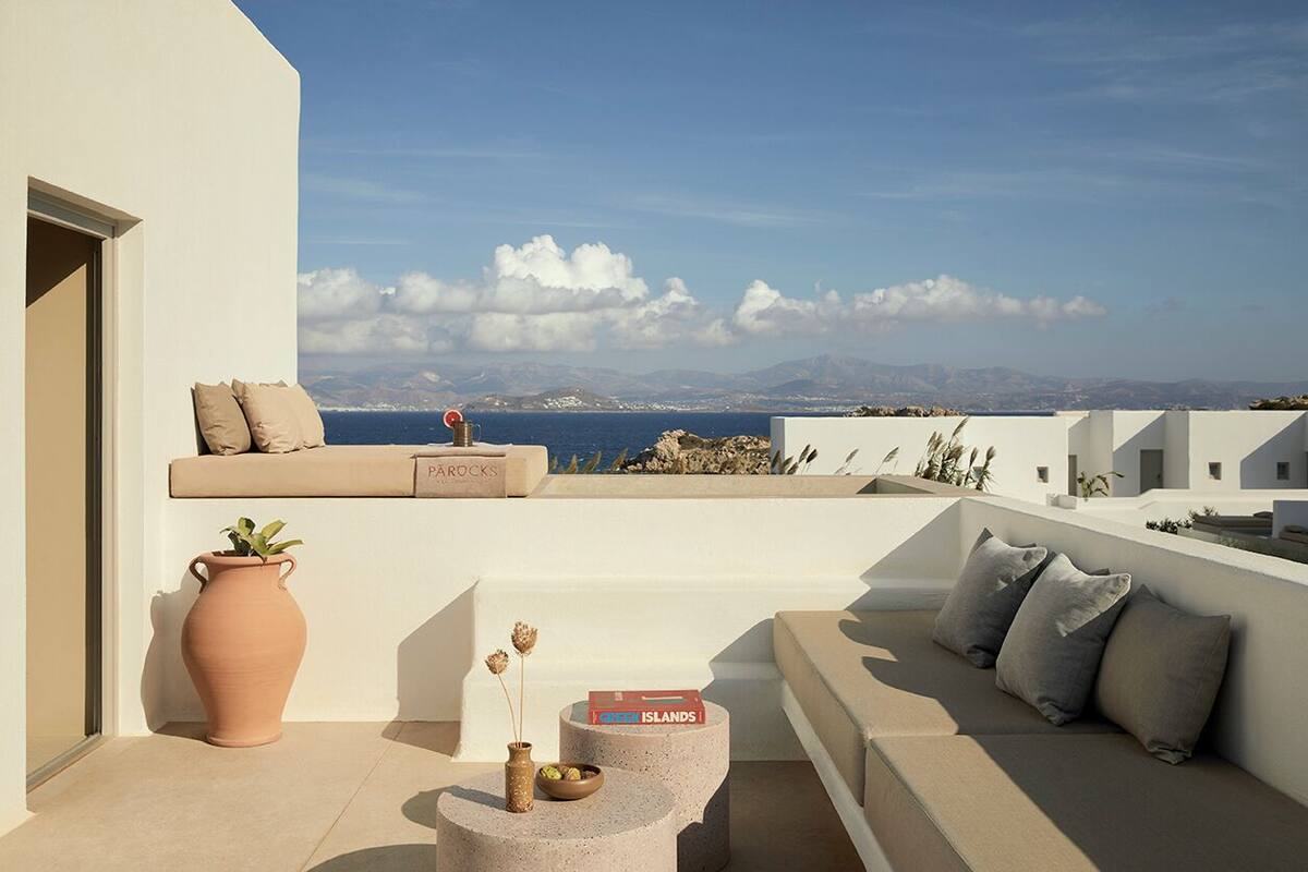 Terraço no telhado com vista para o mar, um vaso de planta, um livro e um vaso.