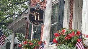 Um edifício de tijolos com uma placa indicando "The Alden House" e bandeiras americanas.