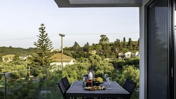 Uma área de refeições externa moderna com mesa e cadeiras, com vista para uma área residencial.