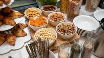 Um buffet de café da manhã com diversos pães, nozes e frutas secas.
