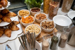 Um buffet de café da manhã com diversos pães, nozes e frutas secas.