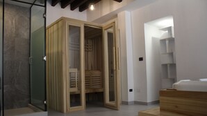 Casa de banho moderna com cabine de duche em vidro, toucador de madeira e prateleiras embutidas.