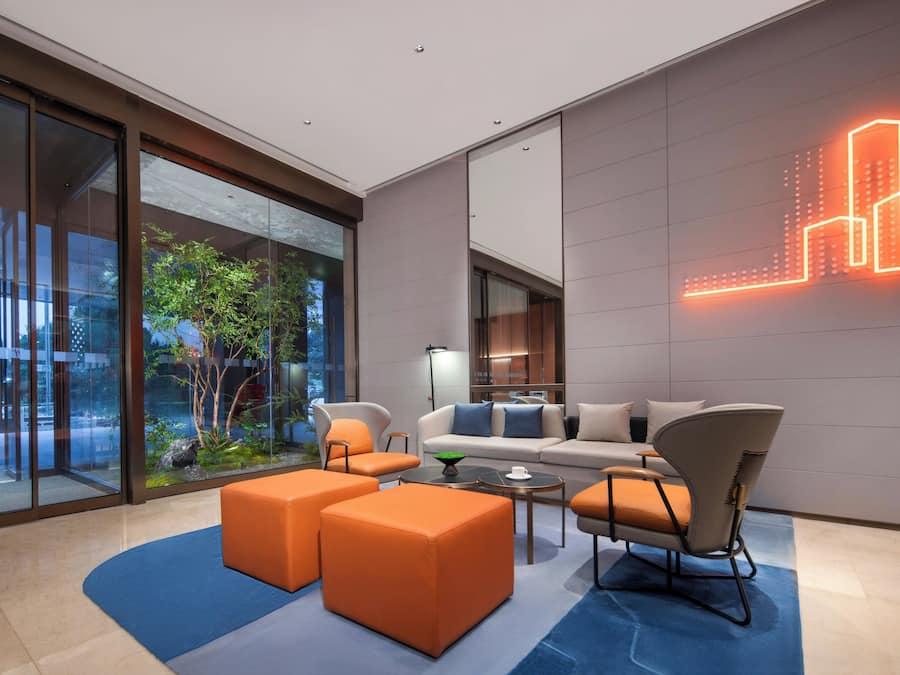 Uma sala de estar moderna com sofá, pufes e mesa de centro.