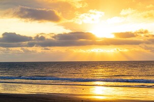 Na praia, espreguiçadeiras, guarda-sóis de praia, toalhas de praia