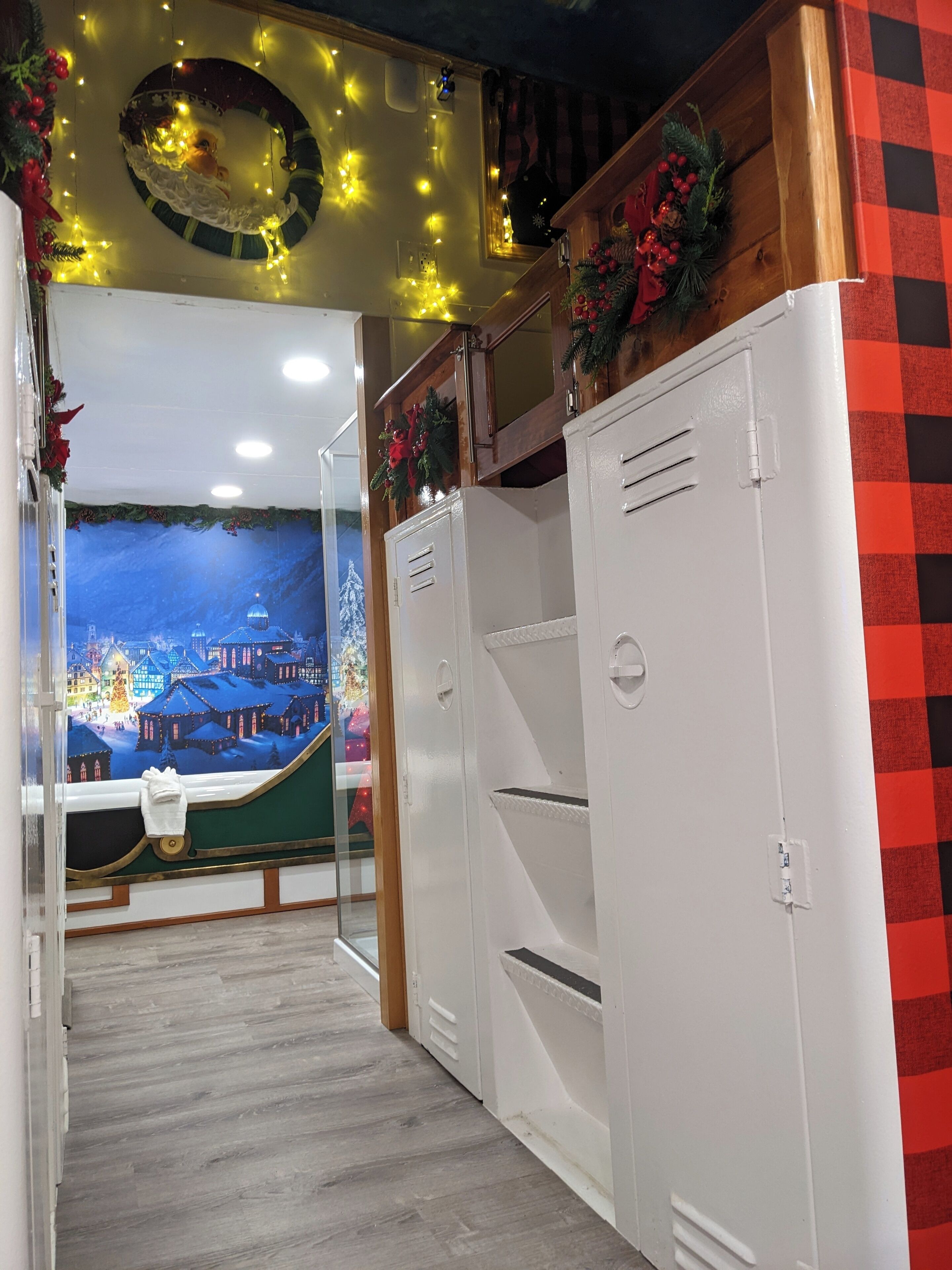 Um corredor com armários, um mural com tema natalino e decorações festivas.
