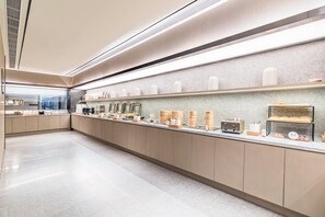 Cozinha moderna com bancada comprida, recipientes de alimentos e eletrodomésticos.