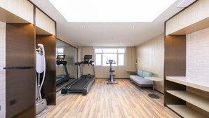 Uma academia moderna com esteiras, bicicleta ergométrica e cadeira de massagem.