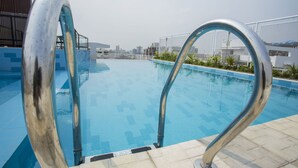 Piscina com guarda-corpos de metal e borda azulejada.