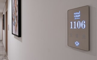 Um painel digital fixado na parede exibindo o número 1106, indicando o número do quarto.