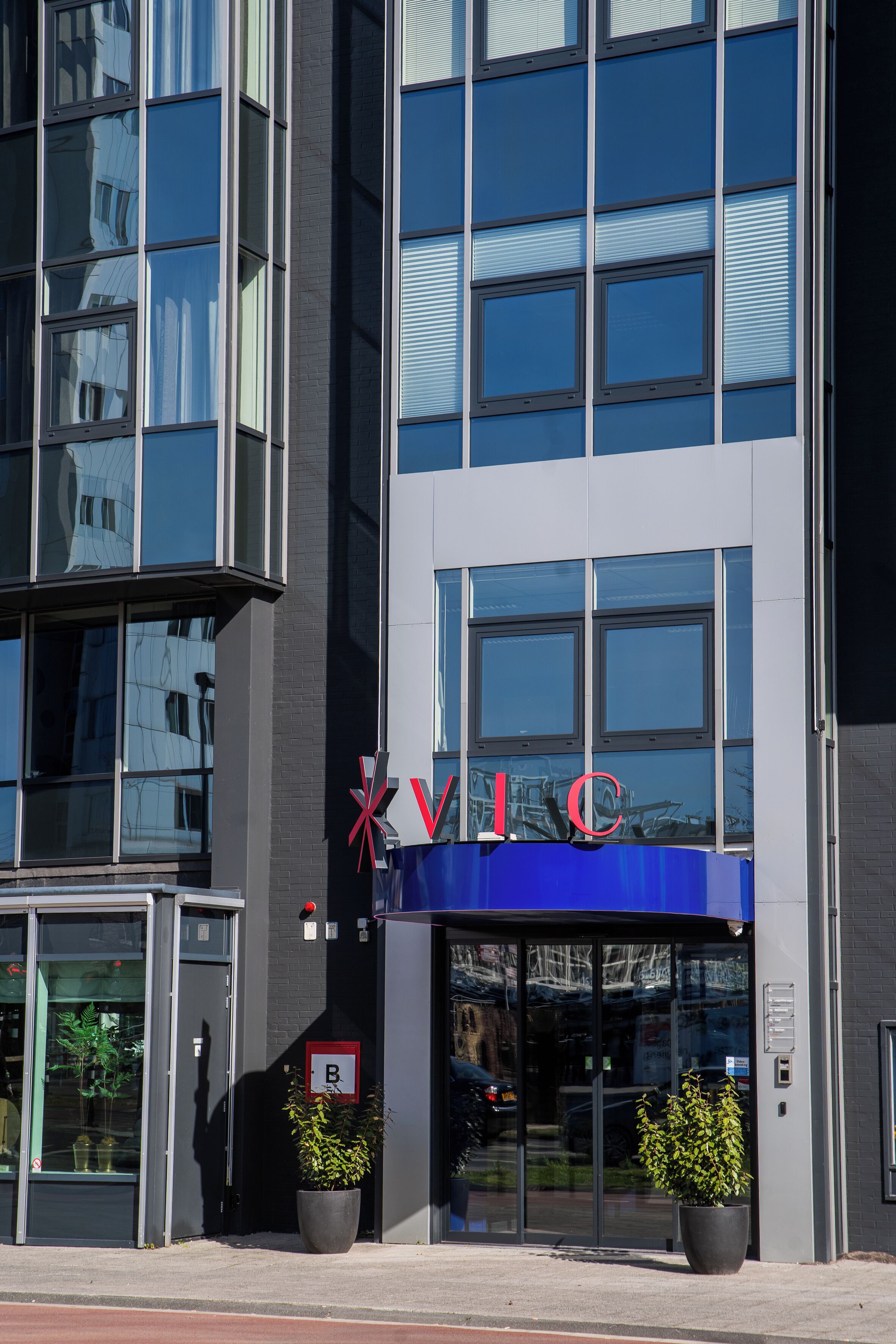 Um edifício moderno com toldo azul e uma placa com a inscrição 