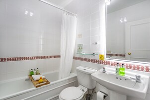 Uma casa de banho com banheira, sanita e lavatório.