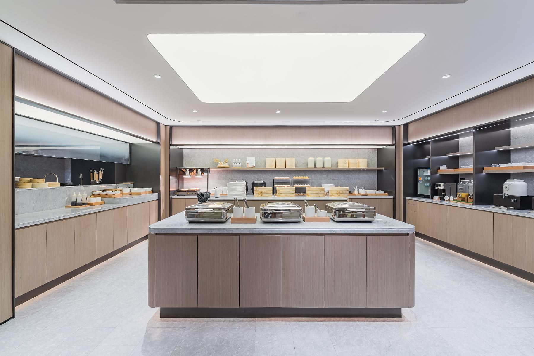 Uma cozinha moderna com ilha central, eletrodomésticos embutidos e um amplo claraboia.