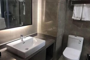 Uma casa de banho moderna com uma sanita, um lavatório e um espelho.