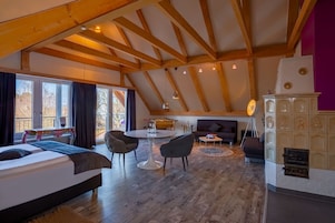 Um amplo quarto no estilo loft com uma cama grande, uma mesa de jantar e um sofá.
