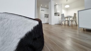 Uma cozinha moderna com armários brancos e um espaço de jantar com mesa e cadeiras brancas.