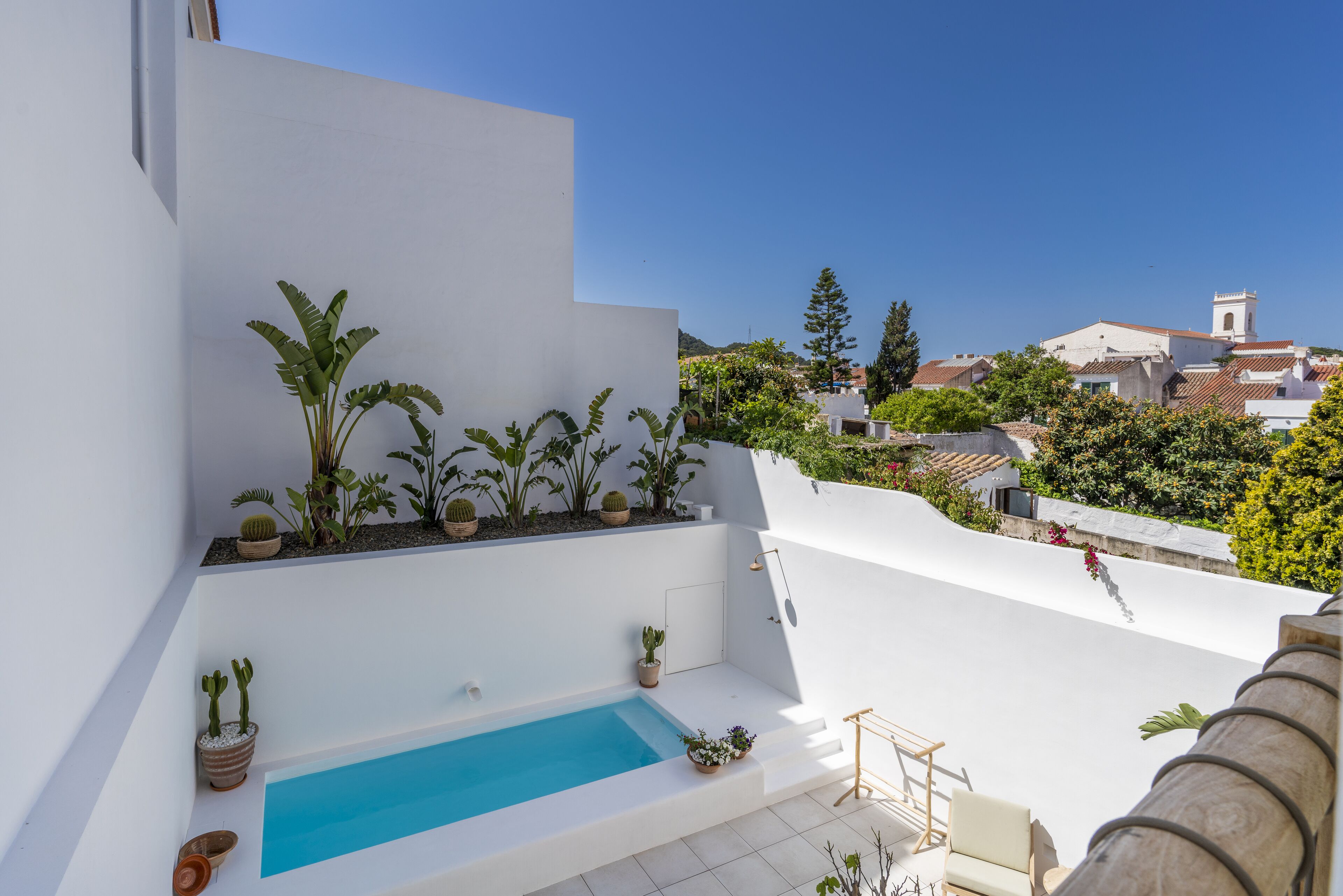 Piscina no terraço com vista desobstruída dos edifícios e vegetação ao redor.