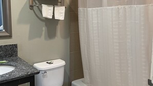 Um banheiro com vaso sanitário, pia e banheira.