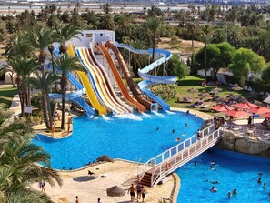 Um parque aquático com vários toboáguas, uma piscina e uma ponte que liga diferentes áreas.