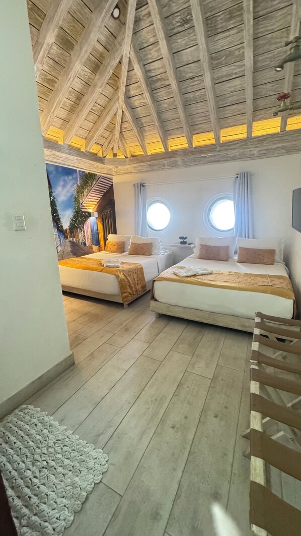 Quarto com duas camas, teto de madeira e um mural na parede.