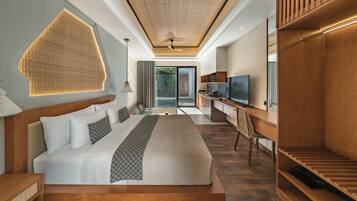 Quarto de hotel moderno com uma cama grande, uma mesa de escritório e uma televisão.