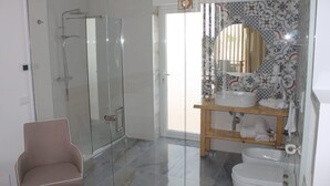 Um banheiro moderno com box de vidro, pia com espelho e vaso sanitário.