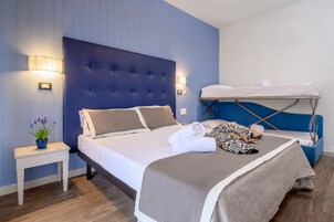 Quarto quádruplo standard | Cofres nos quartos, escrivaninha, Wi-Fi de cortesia, roupa de cama