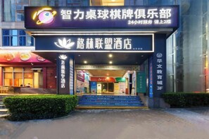 Entrada de hotel com uma placa indicando 'Intelligence Tableball Tableball Club' e 'Tenglin Alliance Hotel'.
